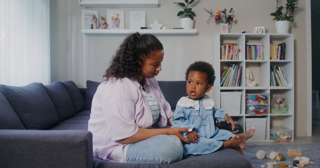 Mother and Child Reading Book on Sofa • Stock Video on Uppbeat